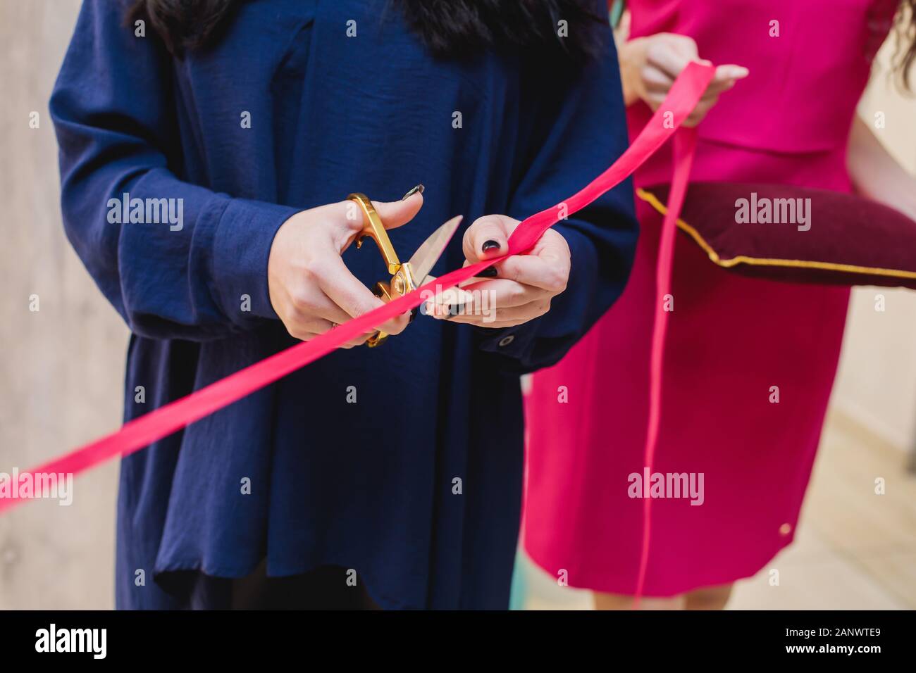 Process of cutting the red ribbon during the grand opening of the new ...