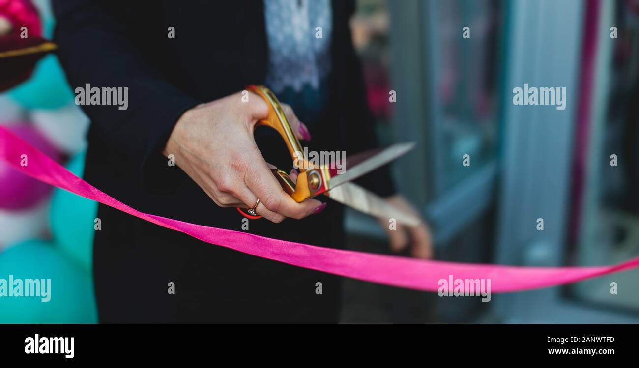 Process of cutting the red ribbon during the grand opening of the new ...