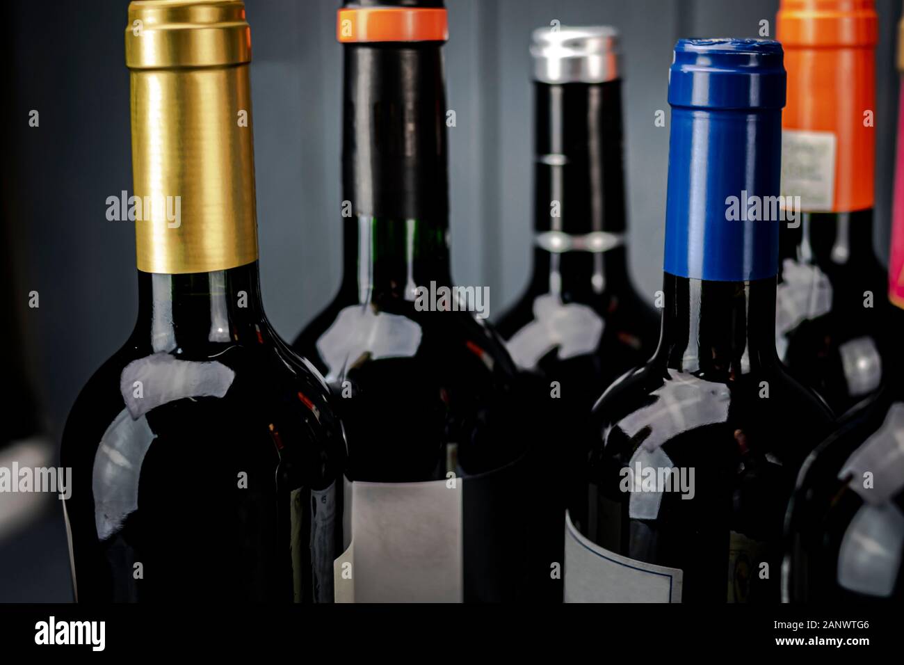 Bottles of red wine grouped with labels of different colors in the ...