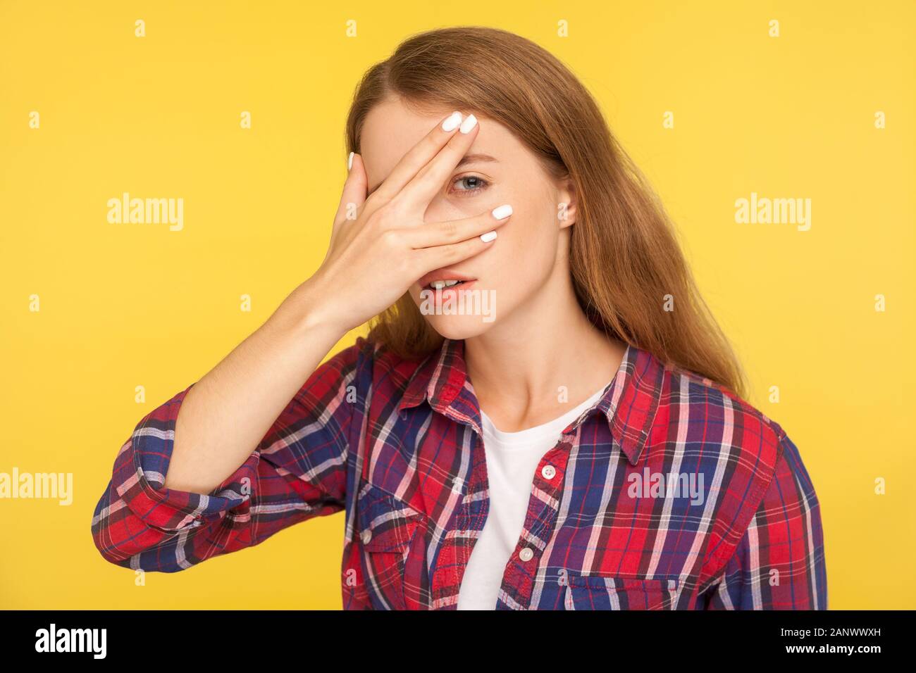 Portrait of nosy inquisitive ginger girl in checkered shirt covering ...