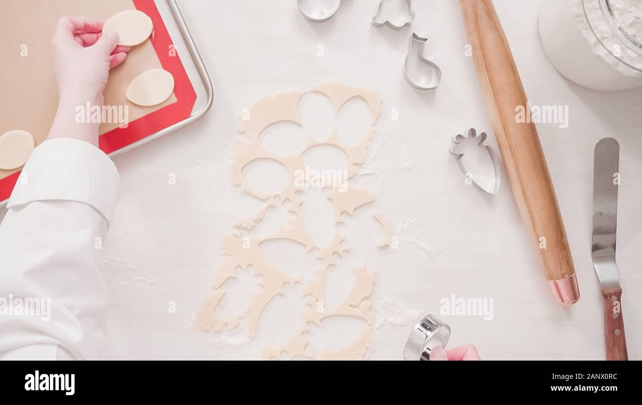 Step by step. Flat lay. Cutting sugar cookie dough with Easter shaped ...