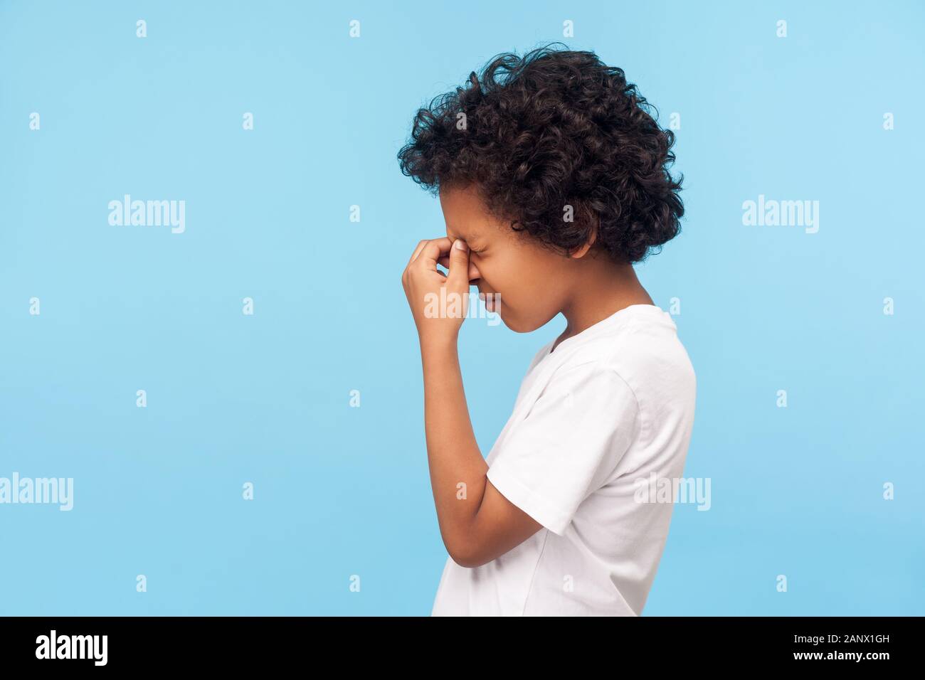 Dramatic sad child emotions. Side view of unhappy little boy with curly ...