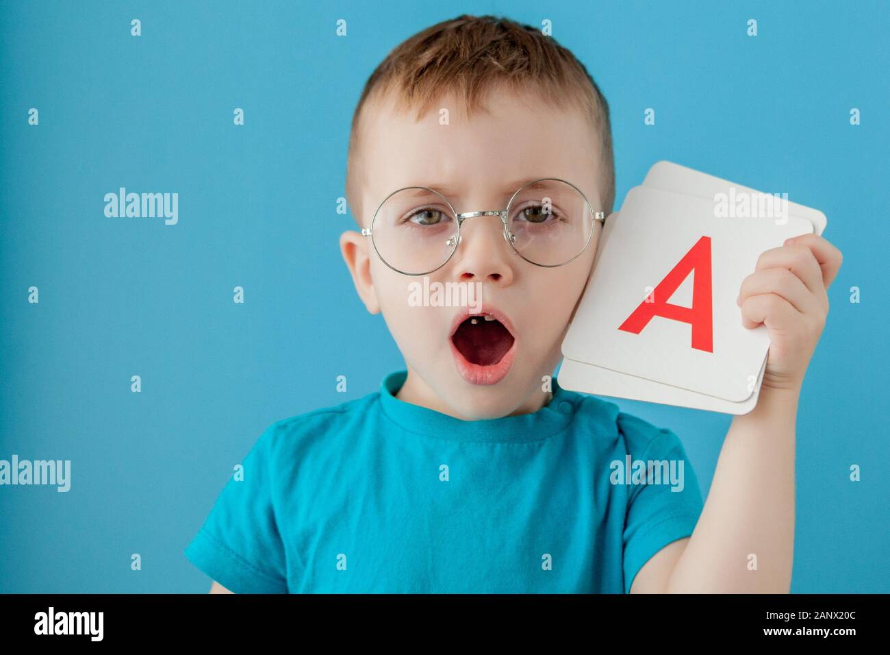 Cute little boy with letter on blue background. Child learning a ...
