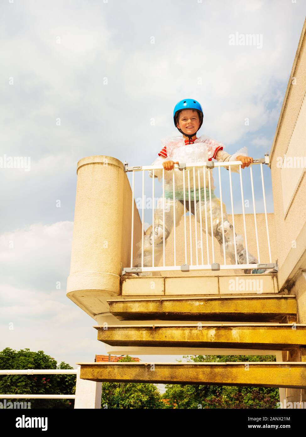 Child stand near kids safe door, stairs in bubble wrap and helmet from ...