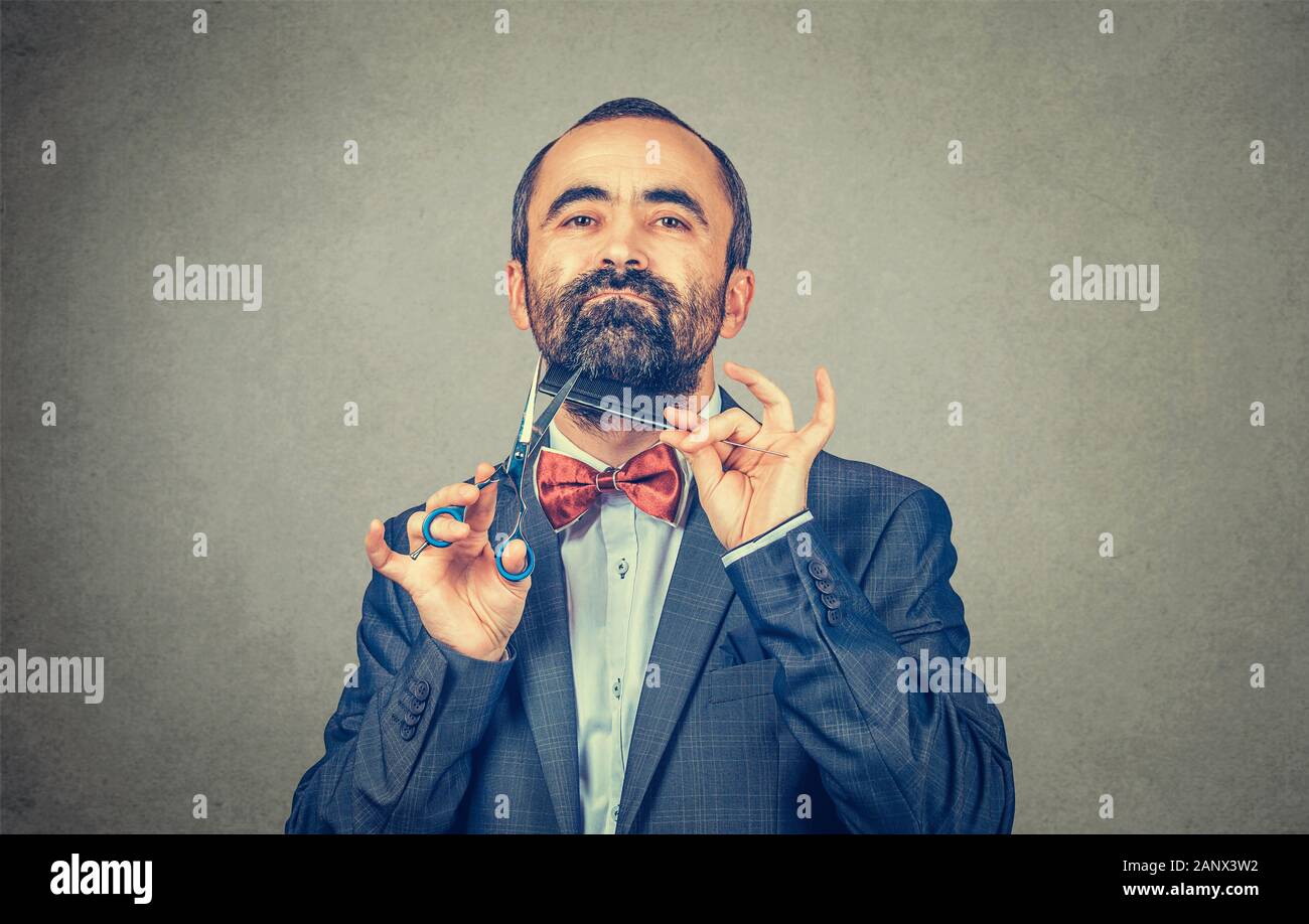 Bearded hairdresser, barber styllist cutting styling his own beard with ...