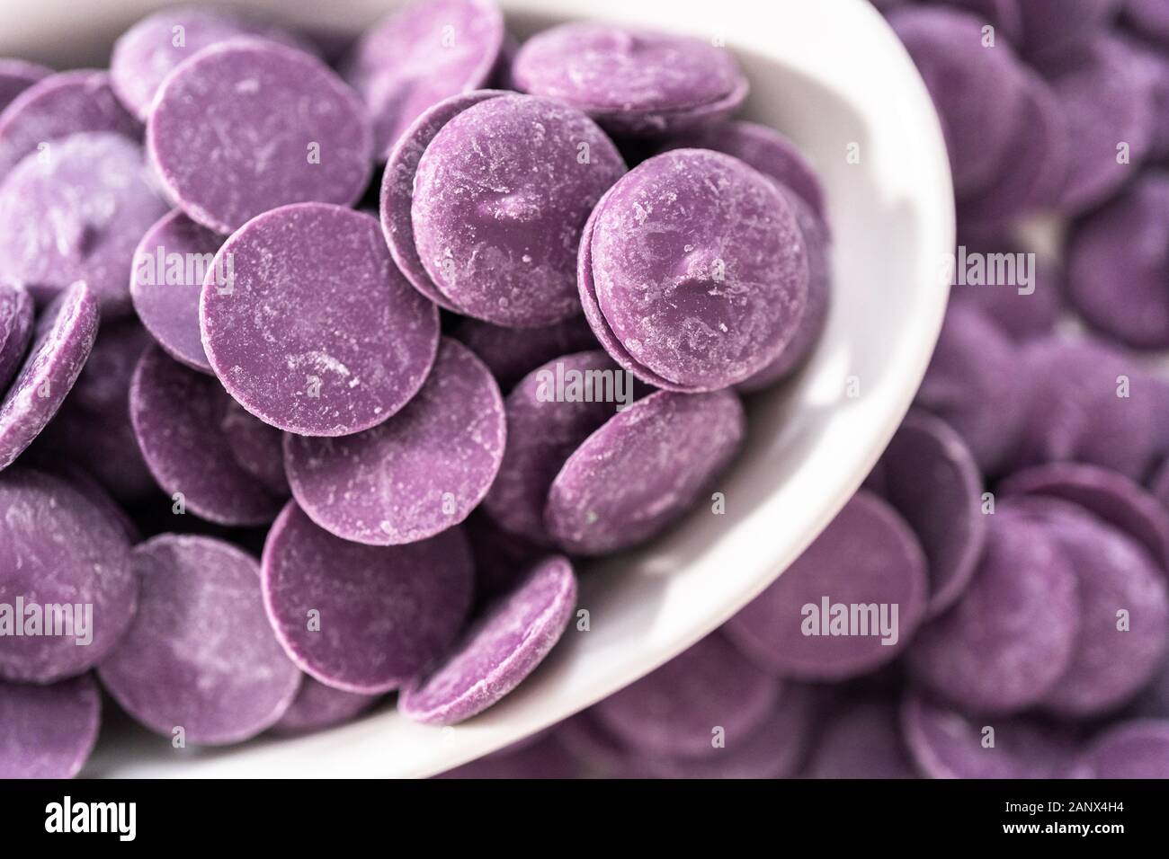 Purple round chocolate chips for melting chocolate shapes on a white ...