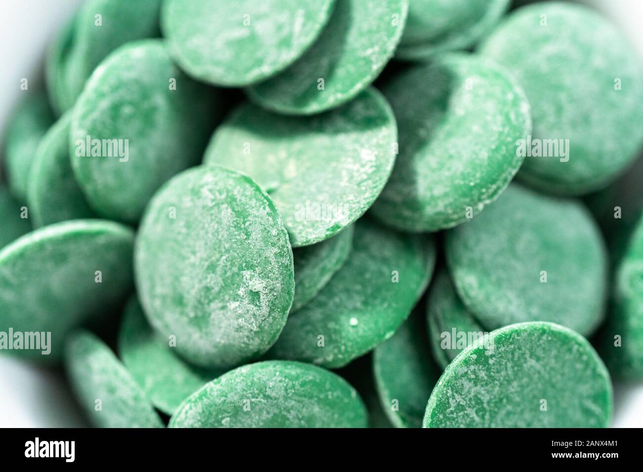 Green round chocolate chips for melting chocolate shapes on a white ...