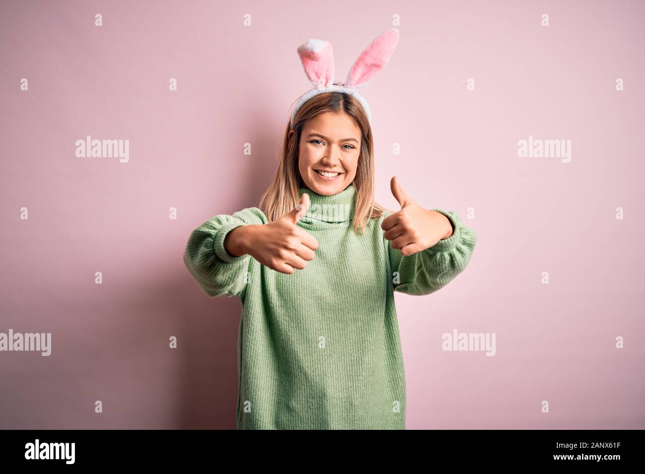 Young beautiful woman wearing easter rabbit ears standing over isolated ...