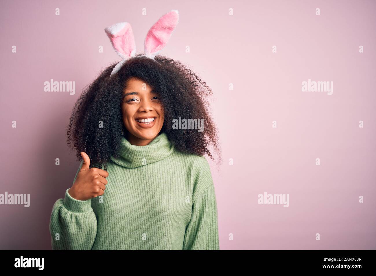 Young african american woman with afro hair wearing easter rabbit ears ...