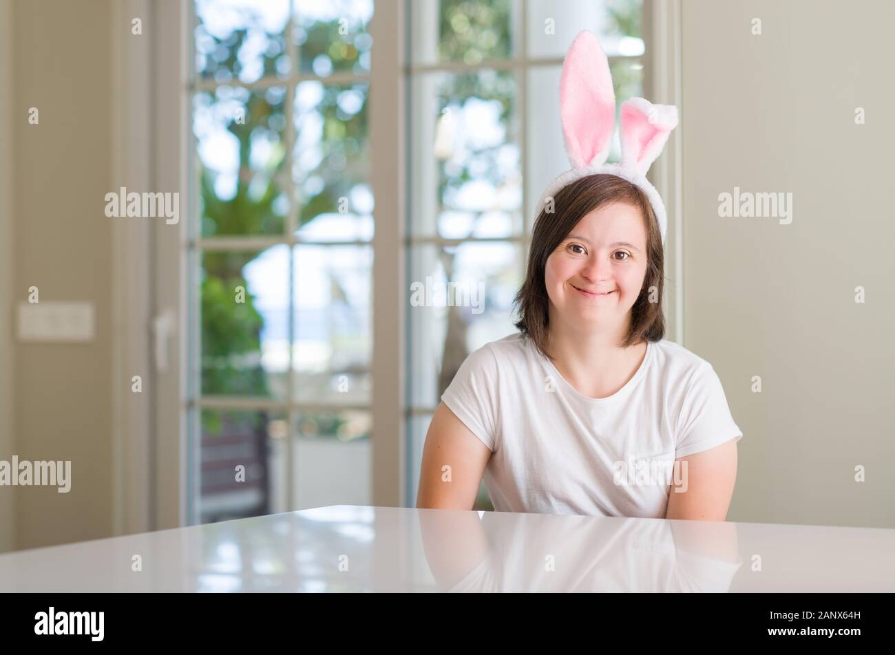 Down syndrome woman at home wearing easter rabbit ears with a happy ...