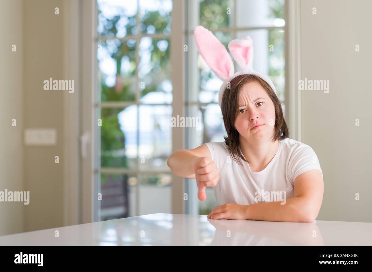 Down syndrome woman at home wearing easter rabbit ears with angry face ...