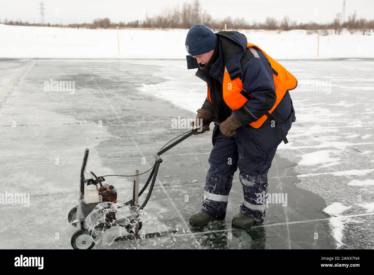 Worker cuts out ice blocks in size on the ice of a frozen lake Stock ...