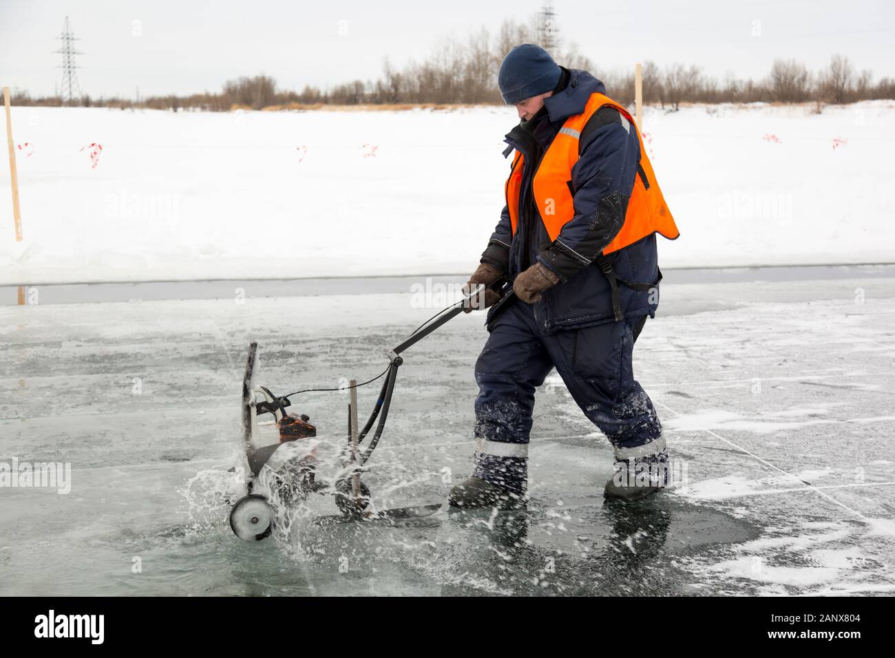Worker cuts out ice blocks in size on the ice of a frozen lake Stock ...