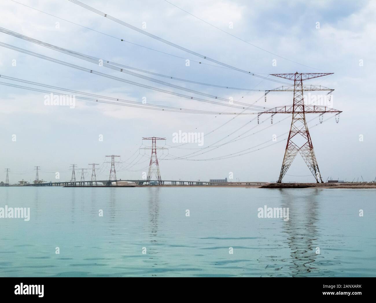 Red and white overhead electricity power lines and cables crossing ...