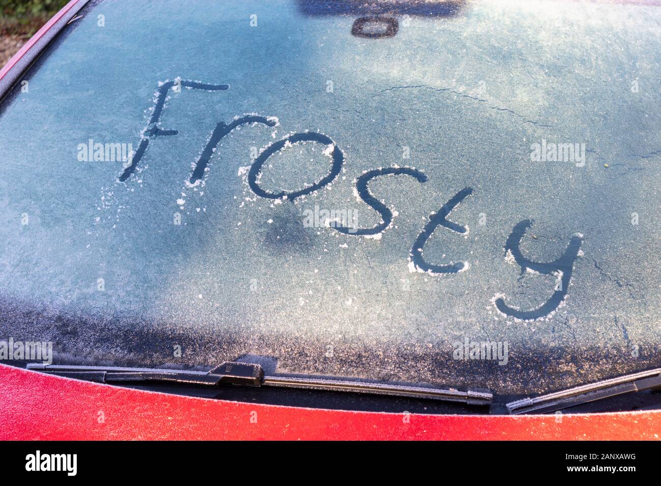 UK weather: the word Frosty written across an icy windscreen of a red ...
