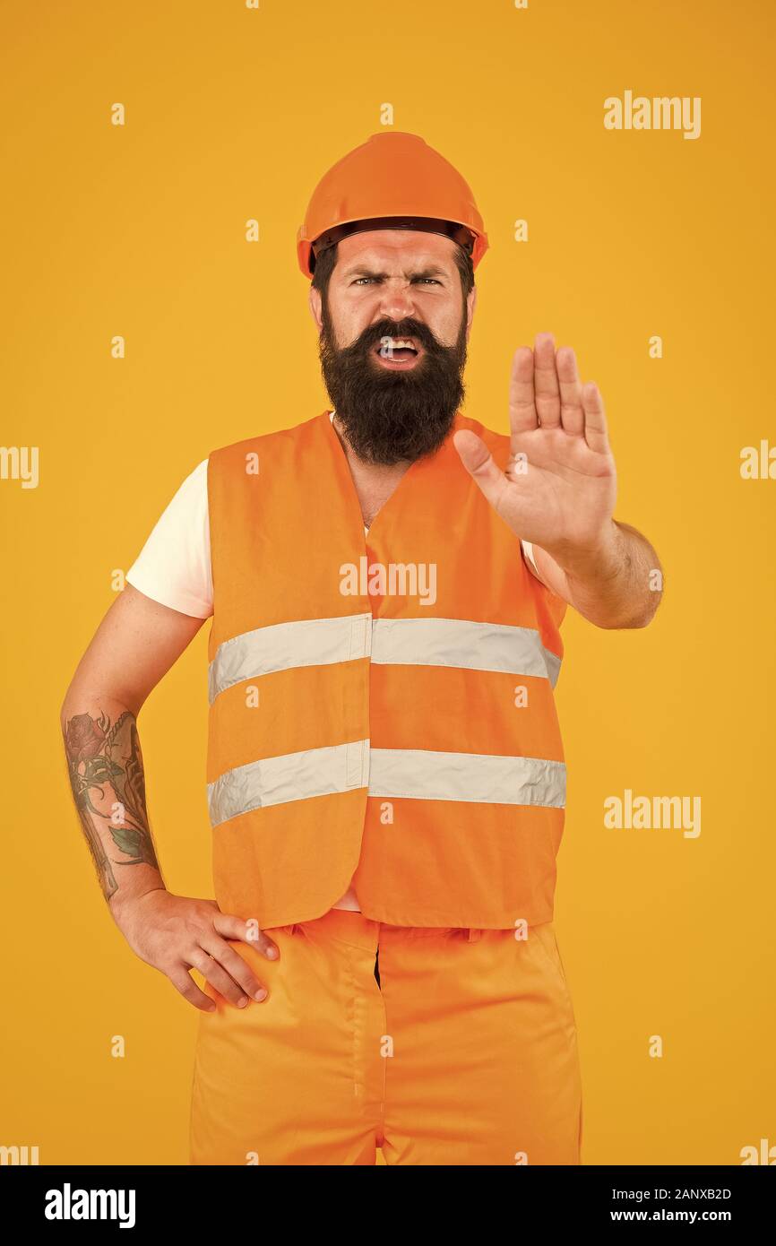 Caution, under construction. Hard worker showing caution sign on yellow ...