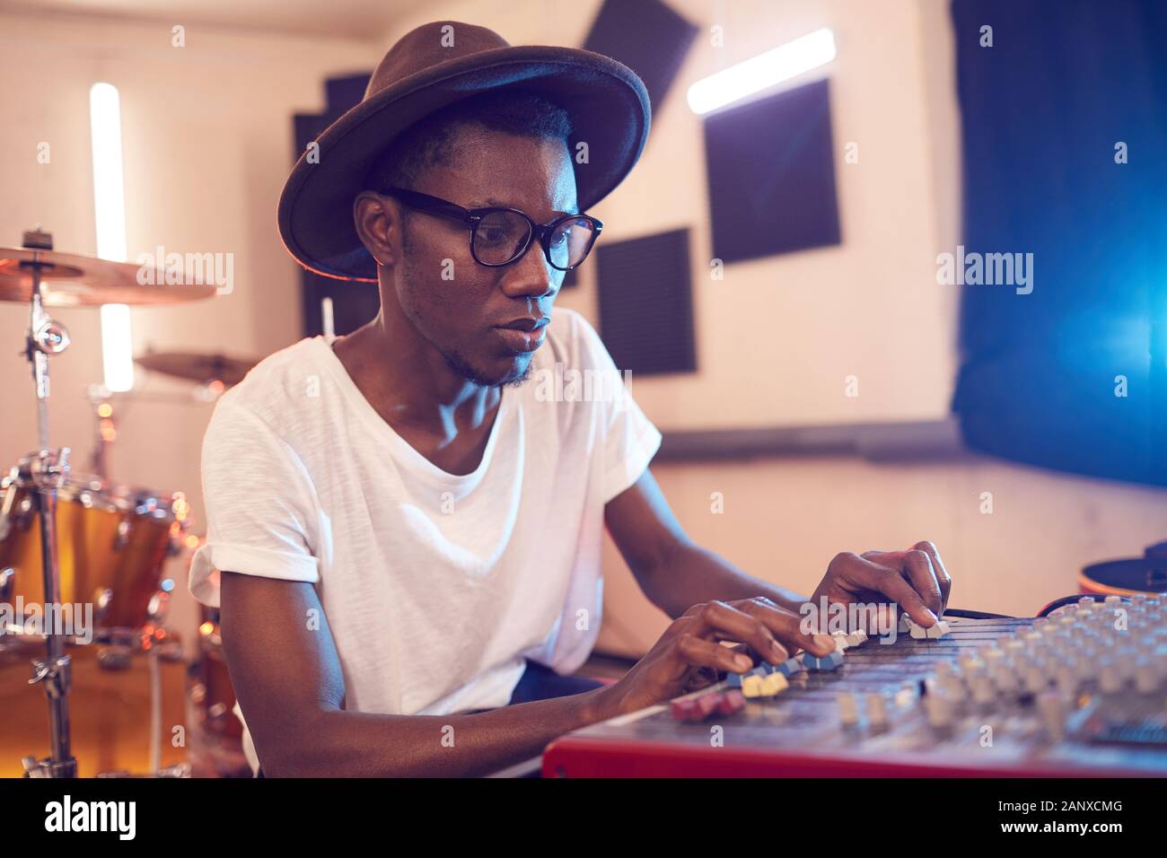 Portrait of young African-American man writing music in recording ...