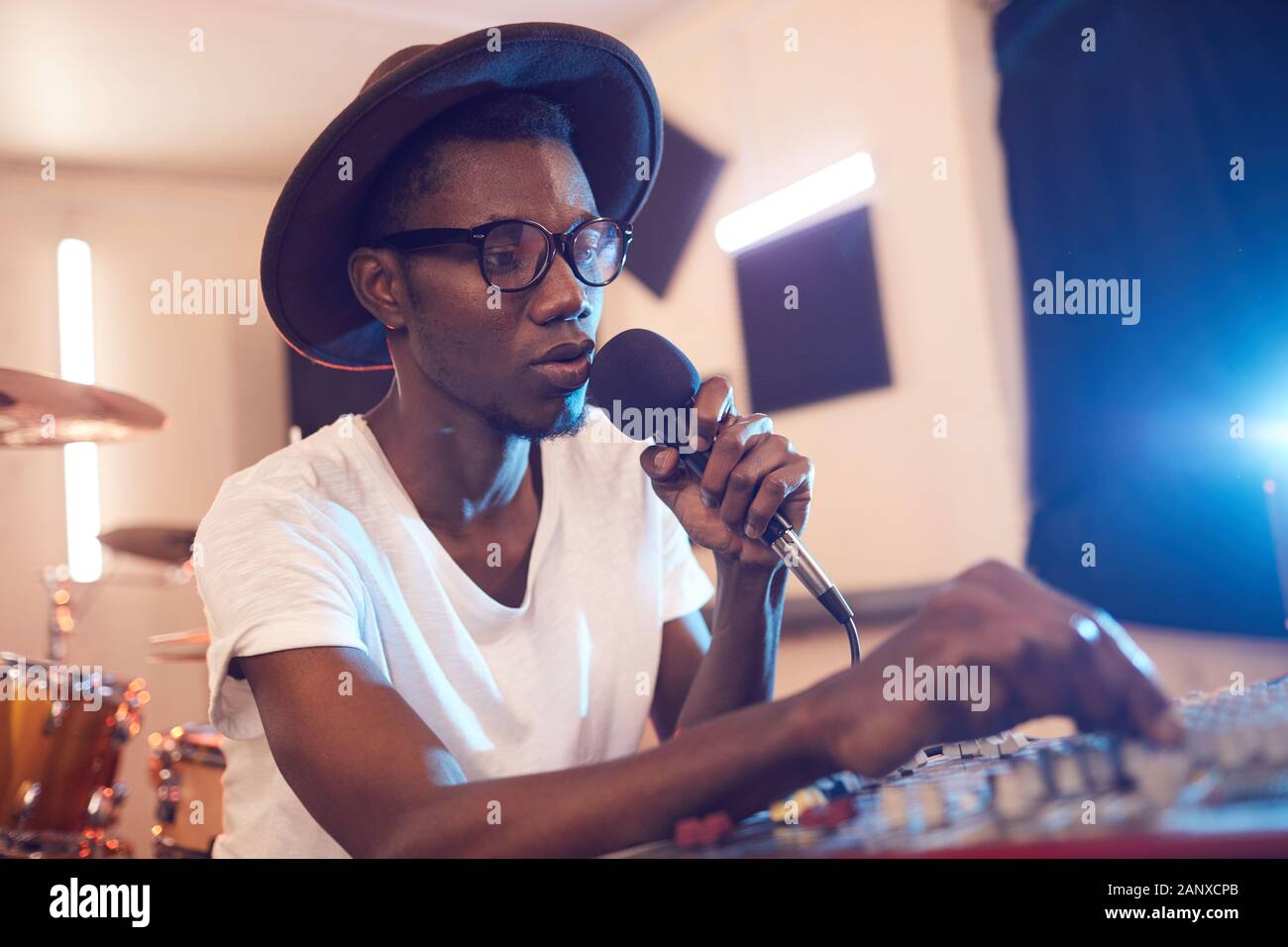 Portrait of young African-American man writing music in recording ...