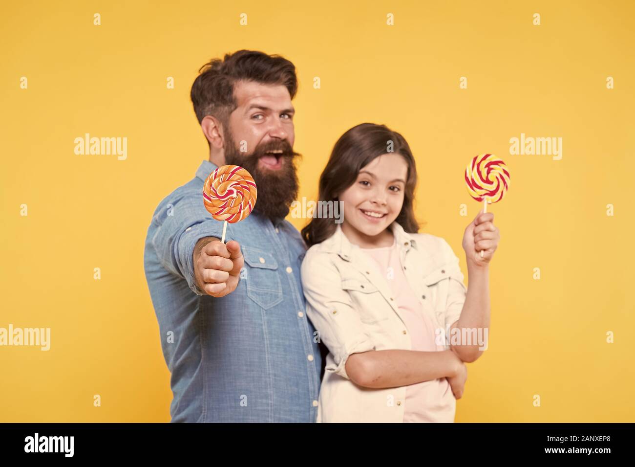 Sweet childhood. Girl child and dad hold colorful lollipops. Sweets and ...
