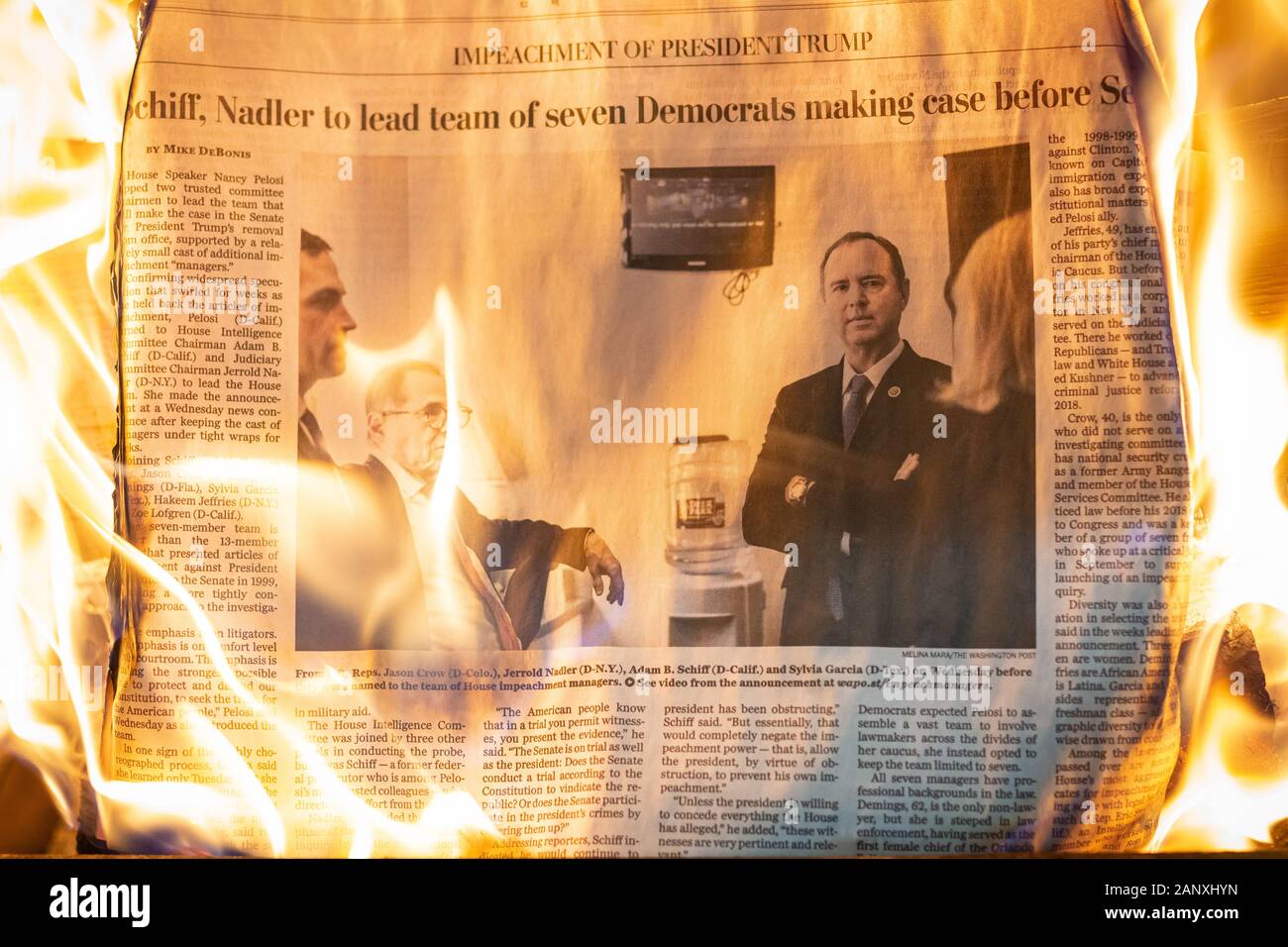 A photo of a newspaper article about the impeachment of Trump burning ...