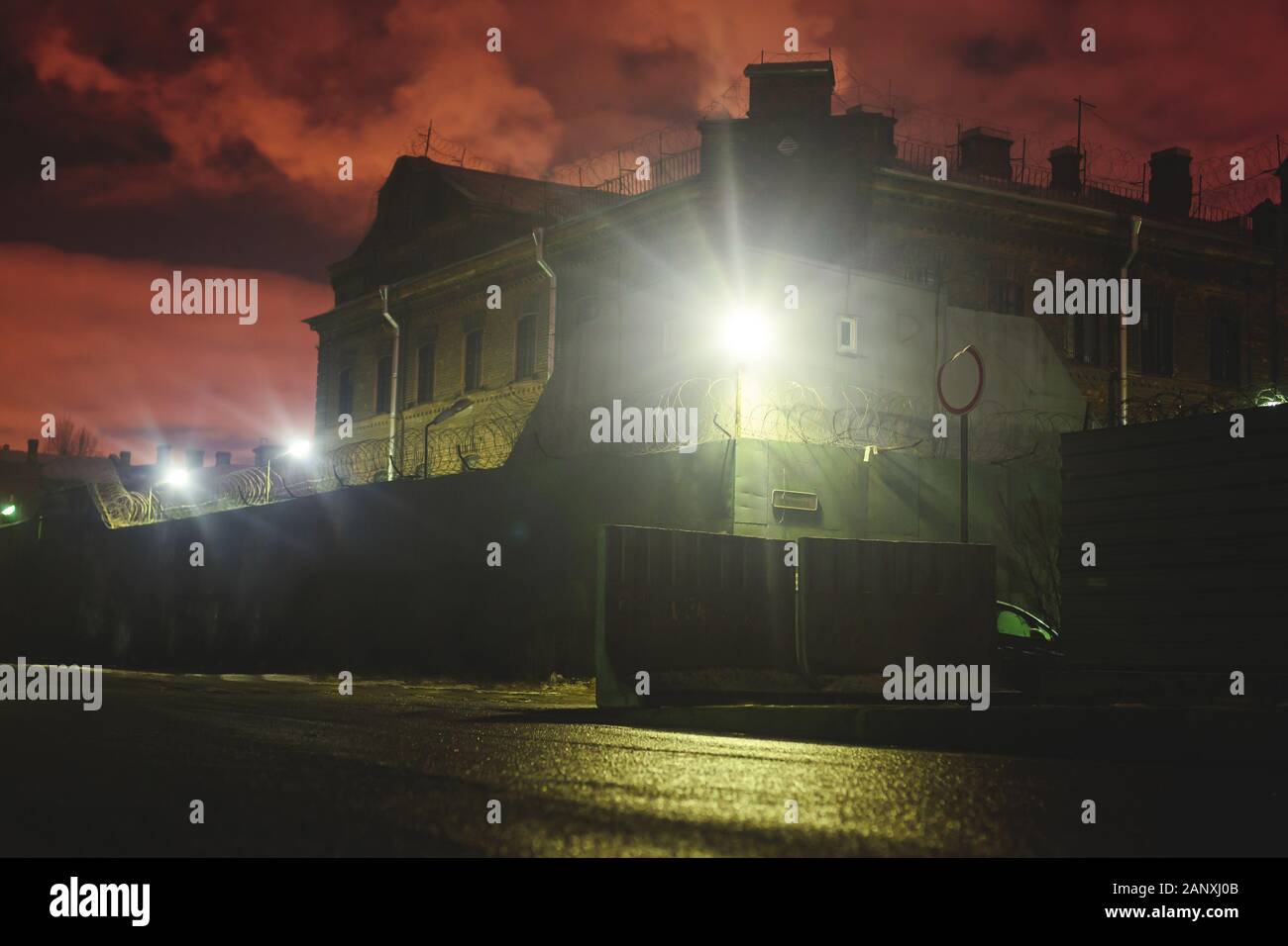 A night view of protected creepy penitentiary prison building facility ...