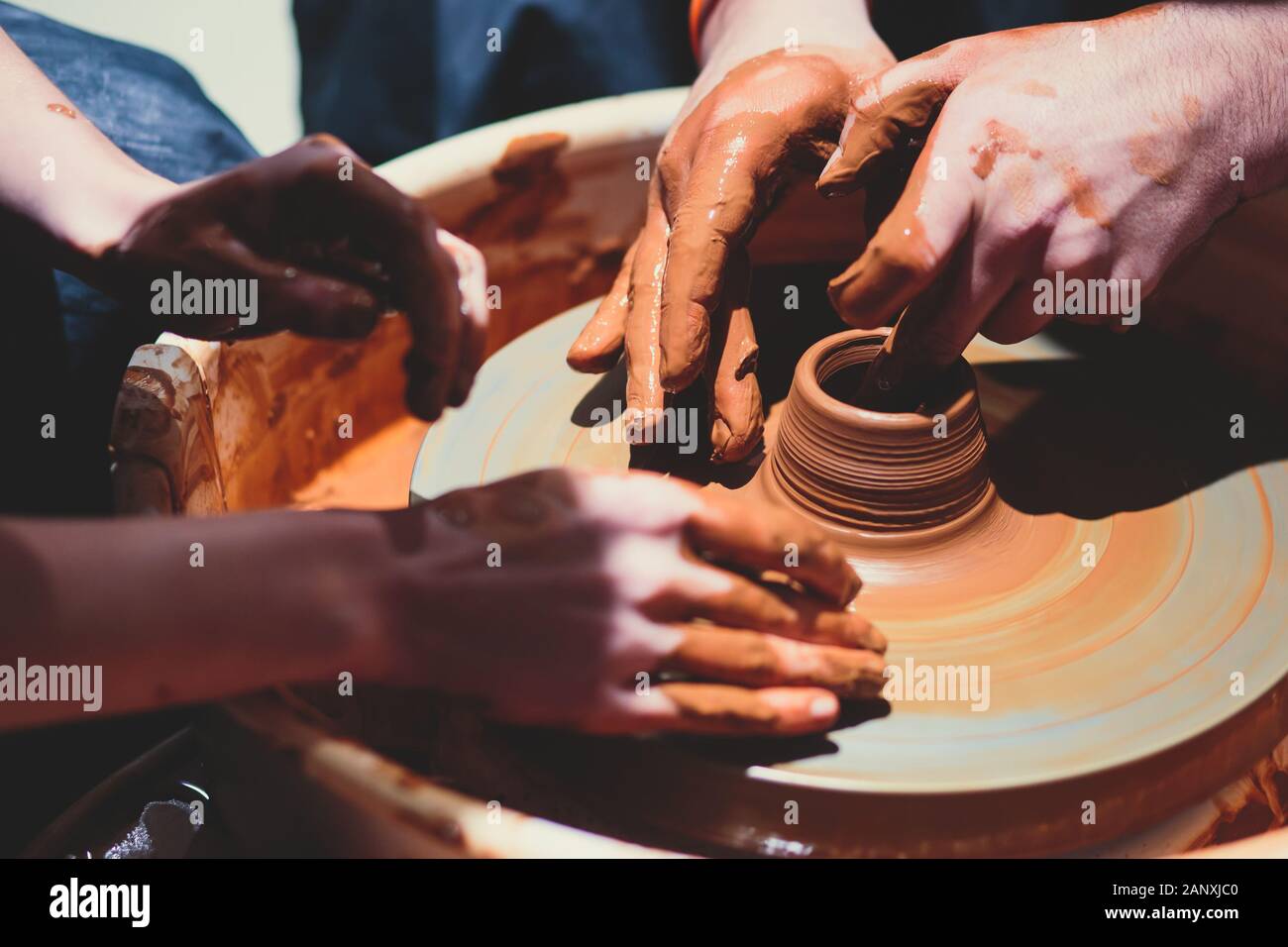 A process of pottery, with two people involved, working on pottery ...