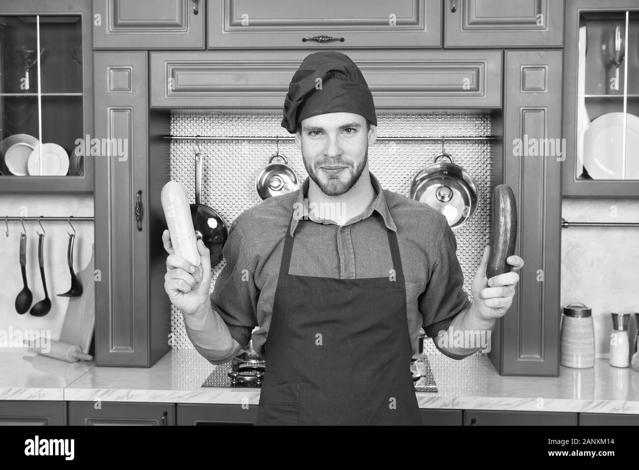 Fresh veggies. Handsome cook in kitchen. Chef following recipe. Cooking ...