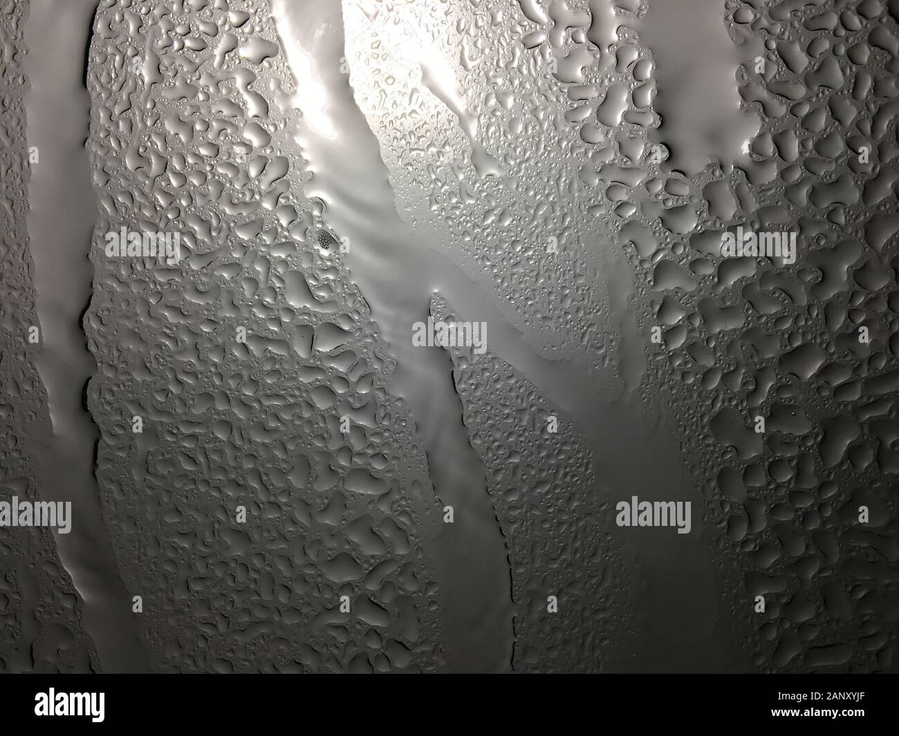 Vehicle windshield view of an automatic car wash with water droplets ...