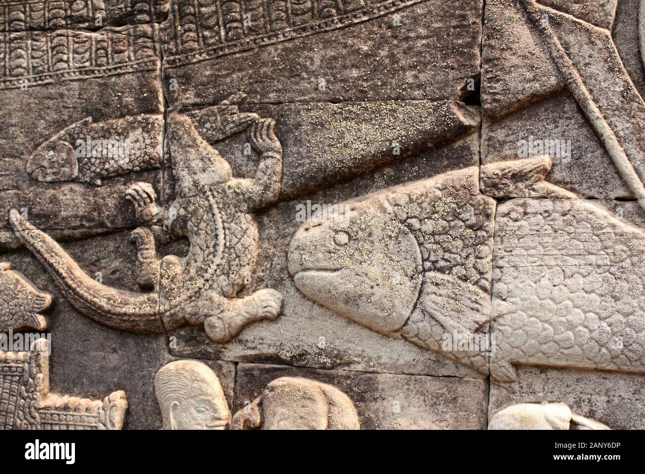 Wall carving bas-relief with animals - crocodile caught a small fish ...