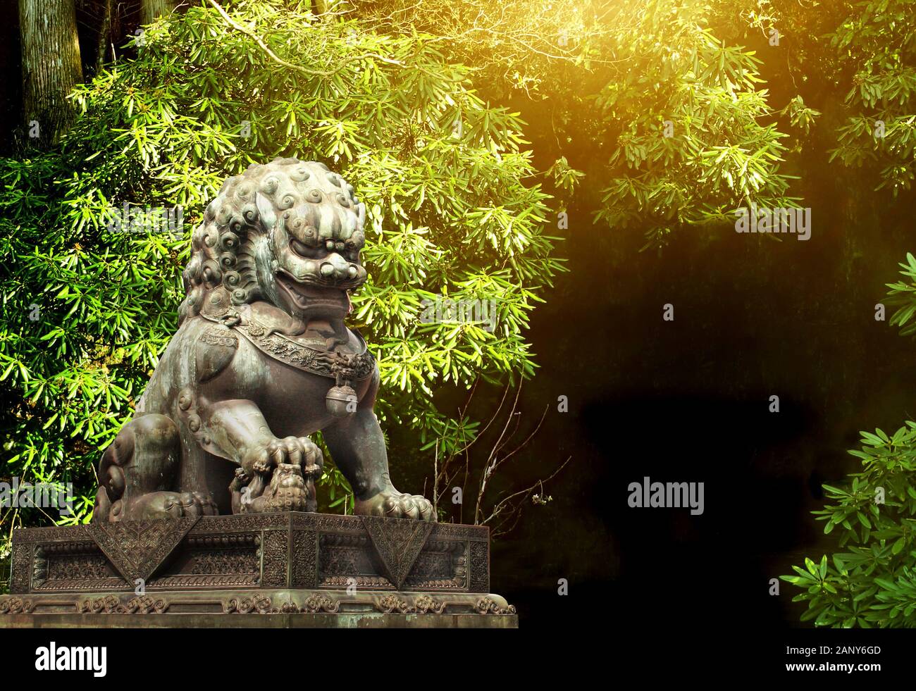 Bronze statue of a lioness with a lion cub in the morning forest ...