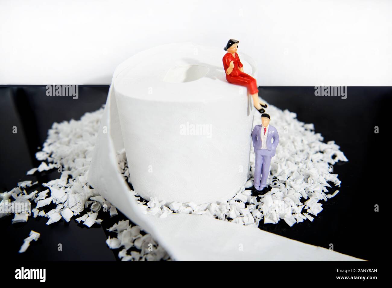 Abstract photo with toilet paper and some small people figures. Waste ...