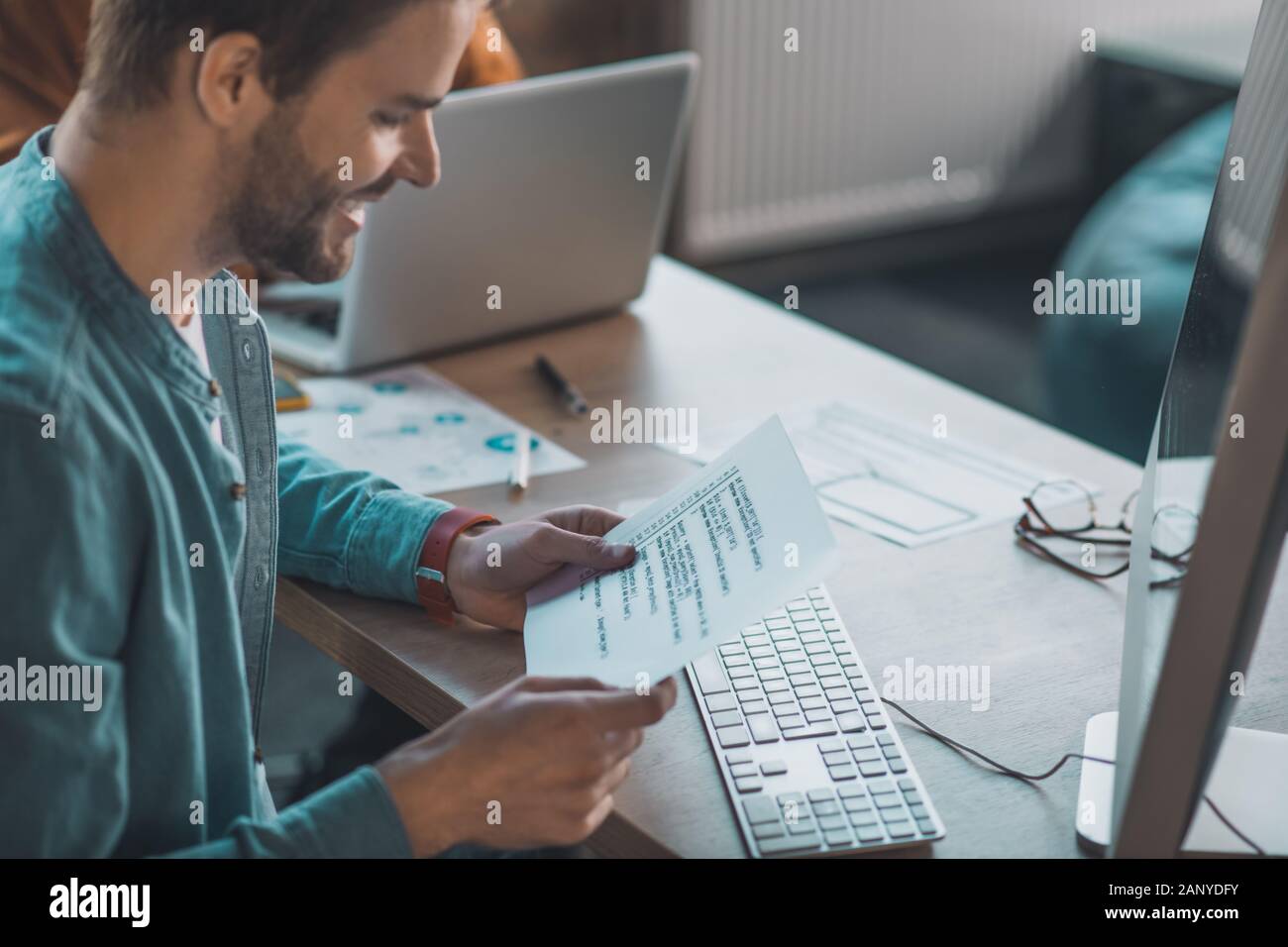 Joyful smart IT man looking at the code Stock Photo - Alamy