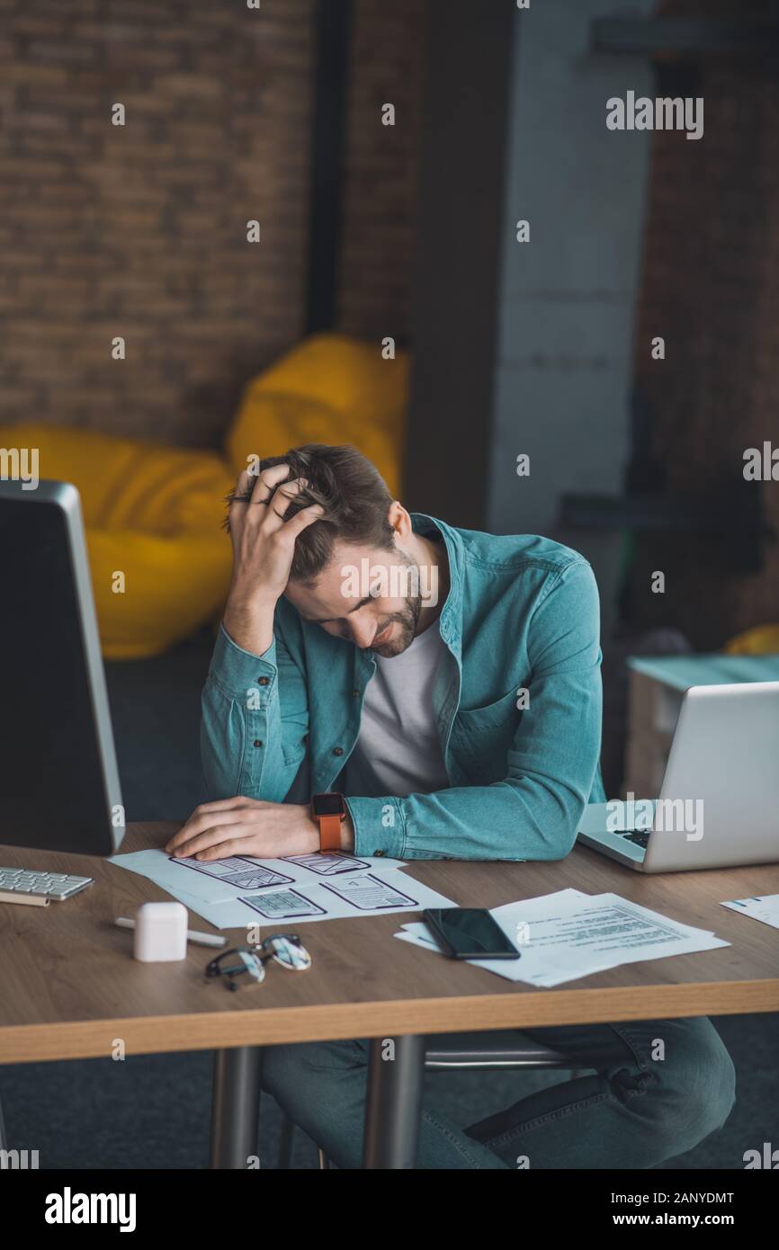 Depressed young man being tired from his work Stock Photo - Alamy