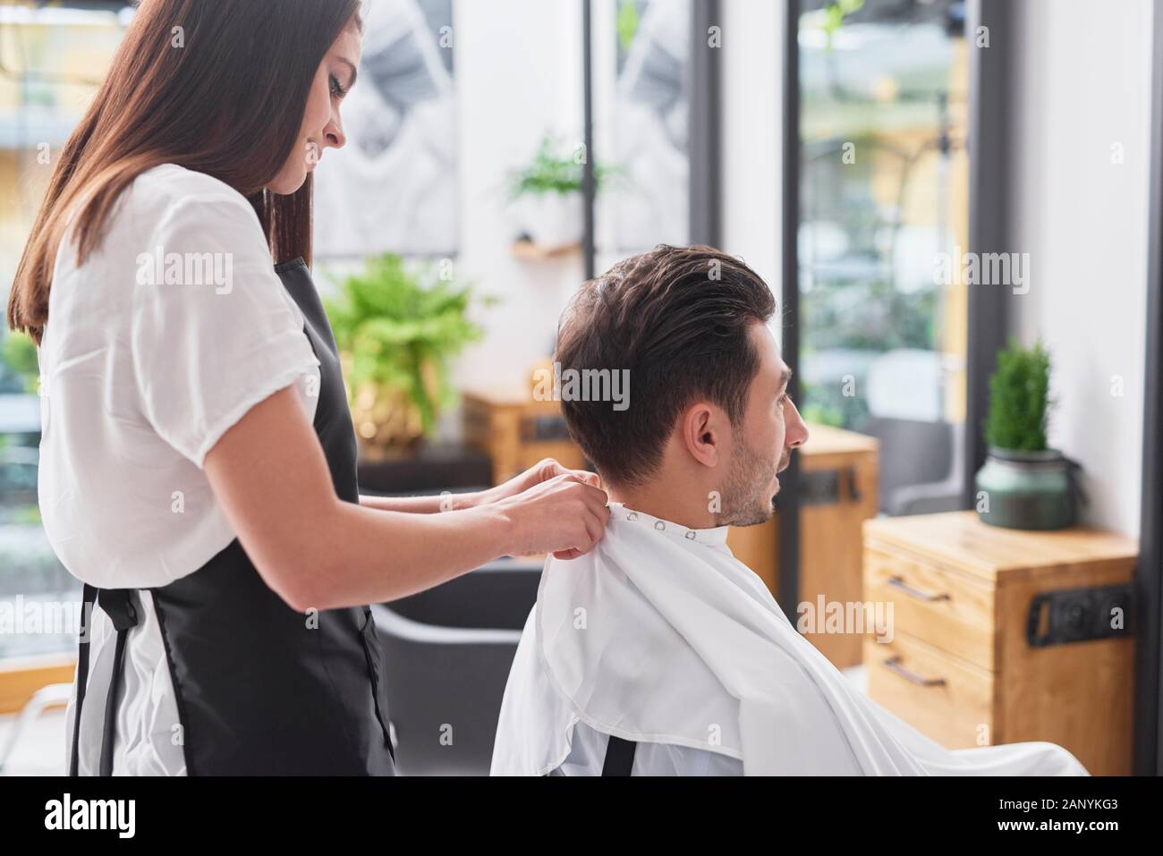 Side view of female hairdresser and man in hair salon Stock Photo - Alamy