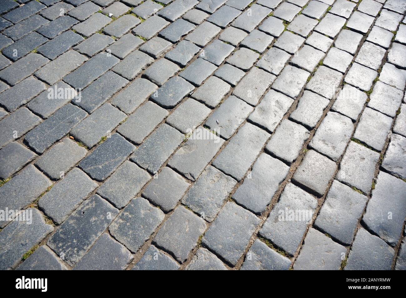 High angle closeup shot of a cobblestone ground with grey square tiles ...