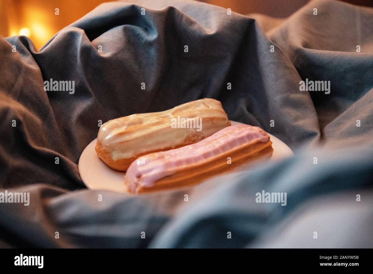 Traditional french eclairs on a white ceramic plate on gray background ...