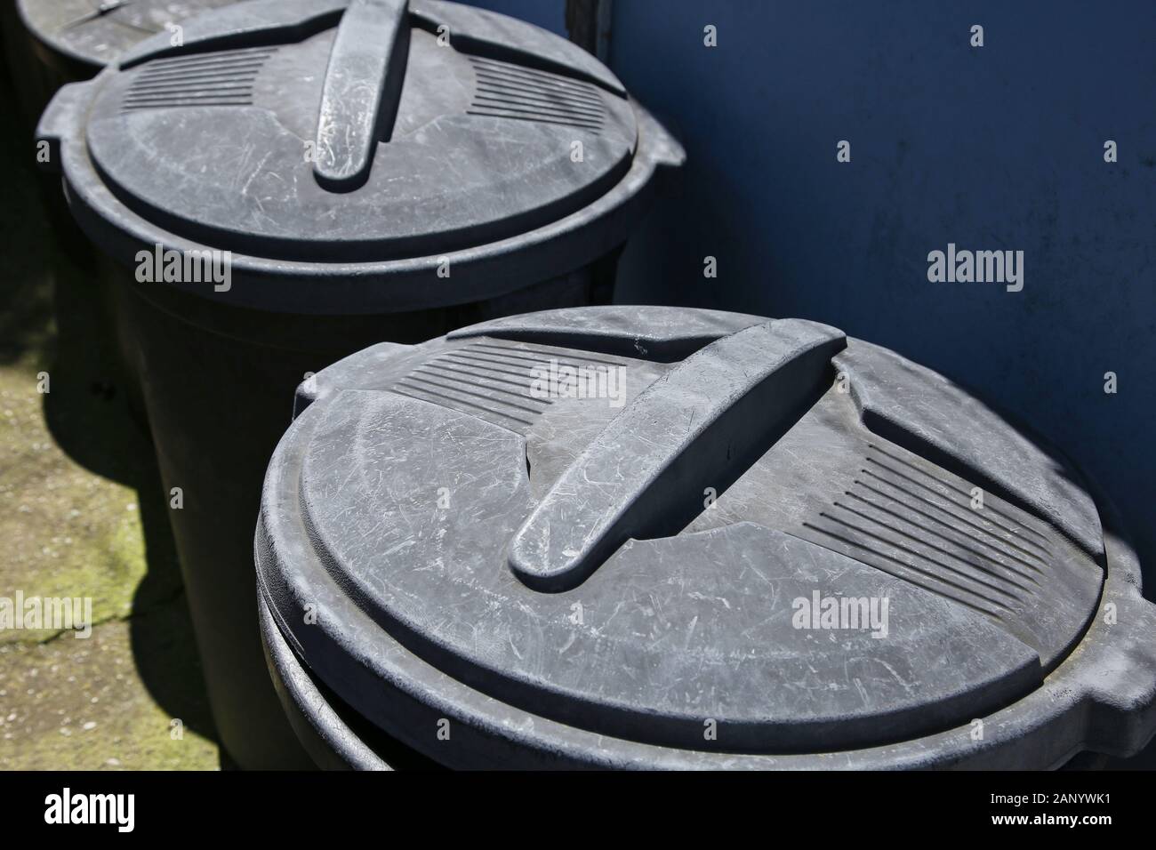 High angle shot of plastic garbage cans next to a building captured at ...