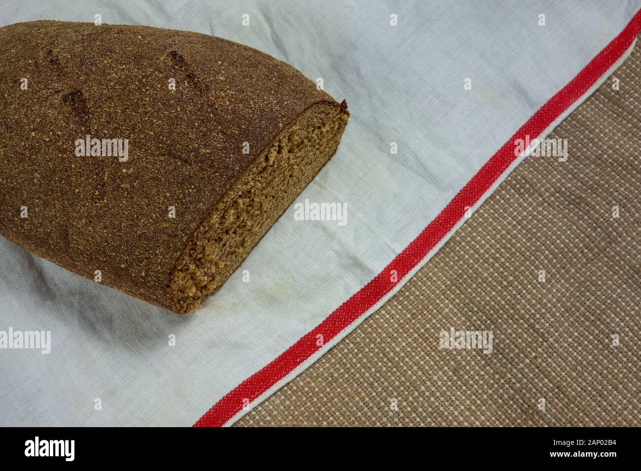 Brown bread on bagging fabric. Closeup view of whole wheat rye bread on ...