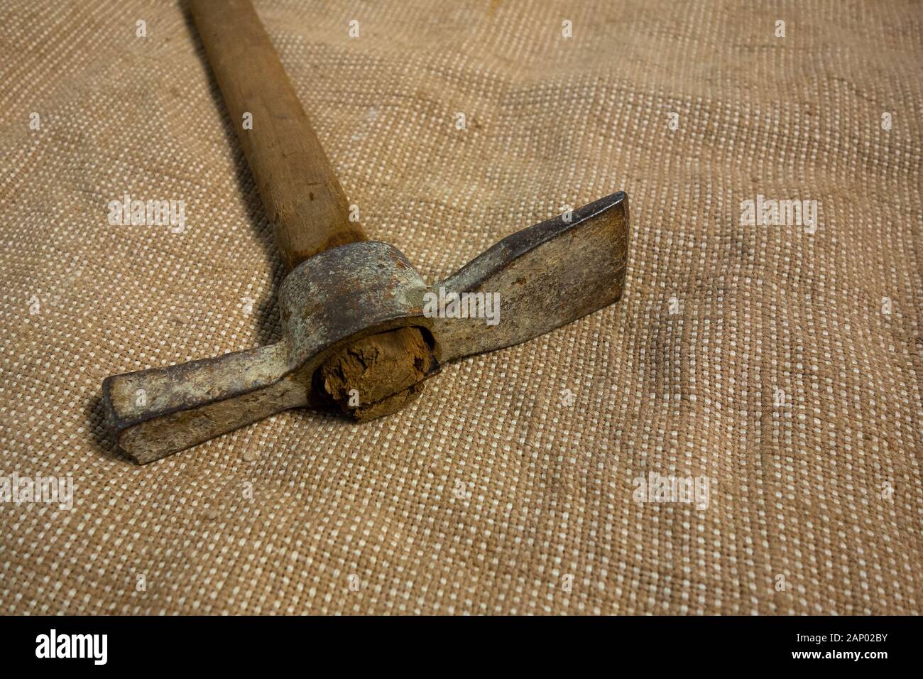 Miner hammer like pickaxe or mattock on bagging fabric background ...