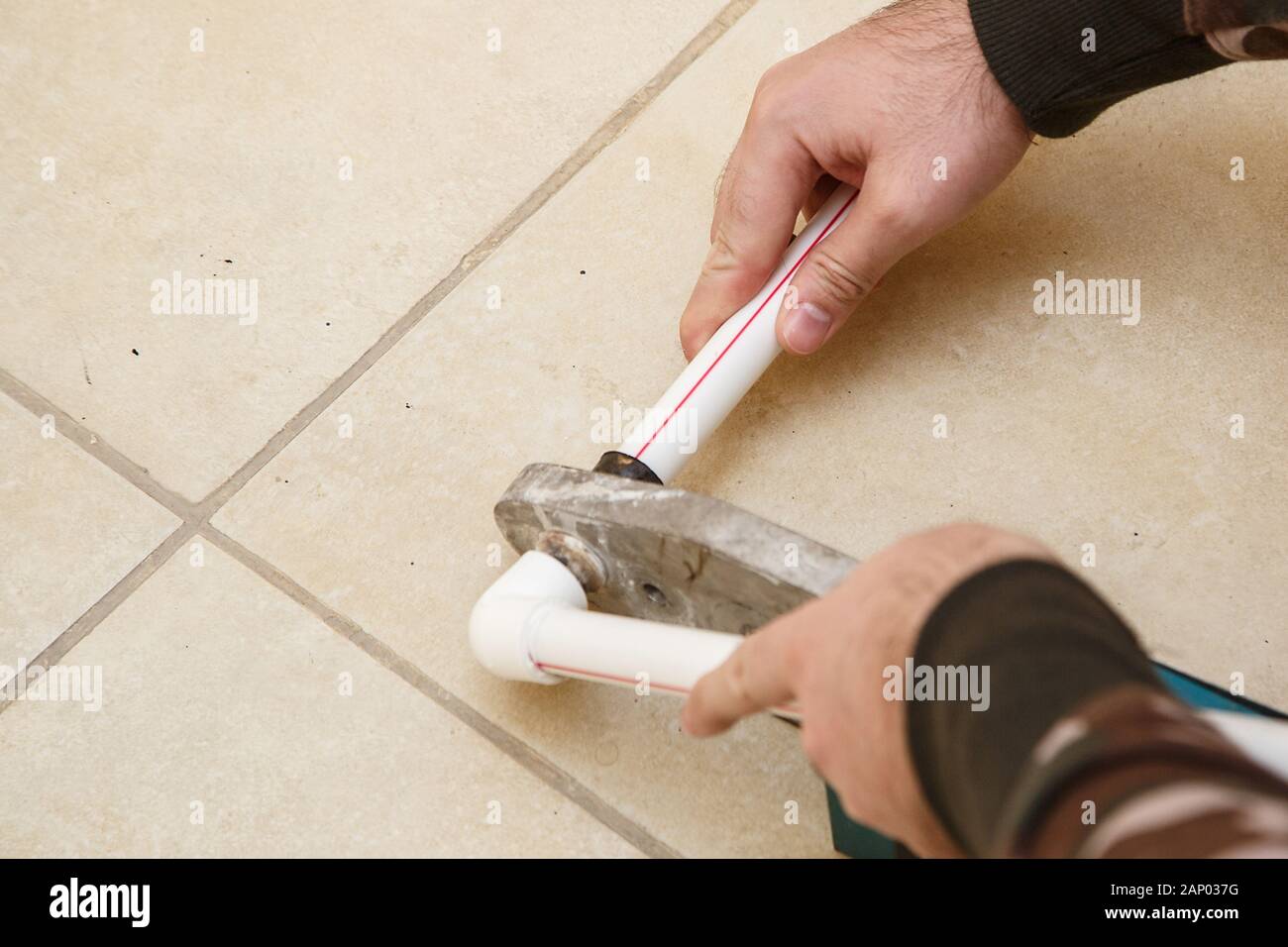 men's hands connect plastic pipes with an iron Stock Photo - Alamy