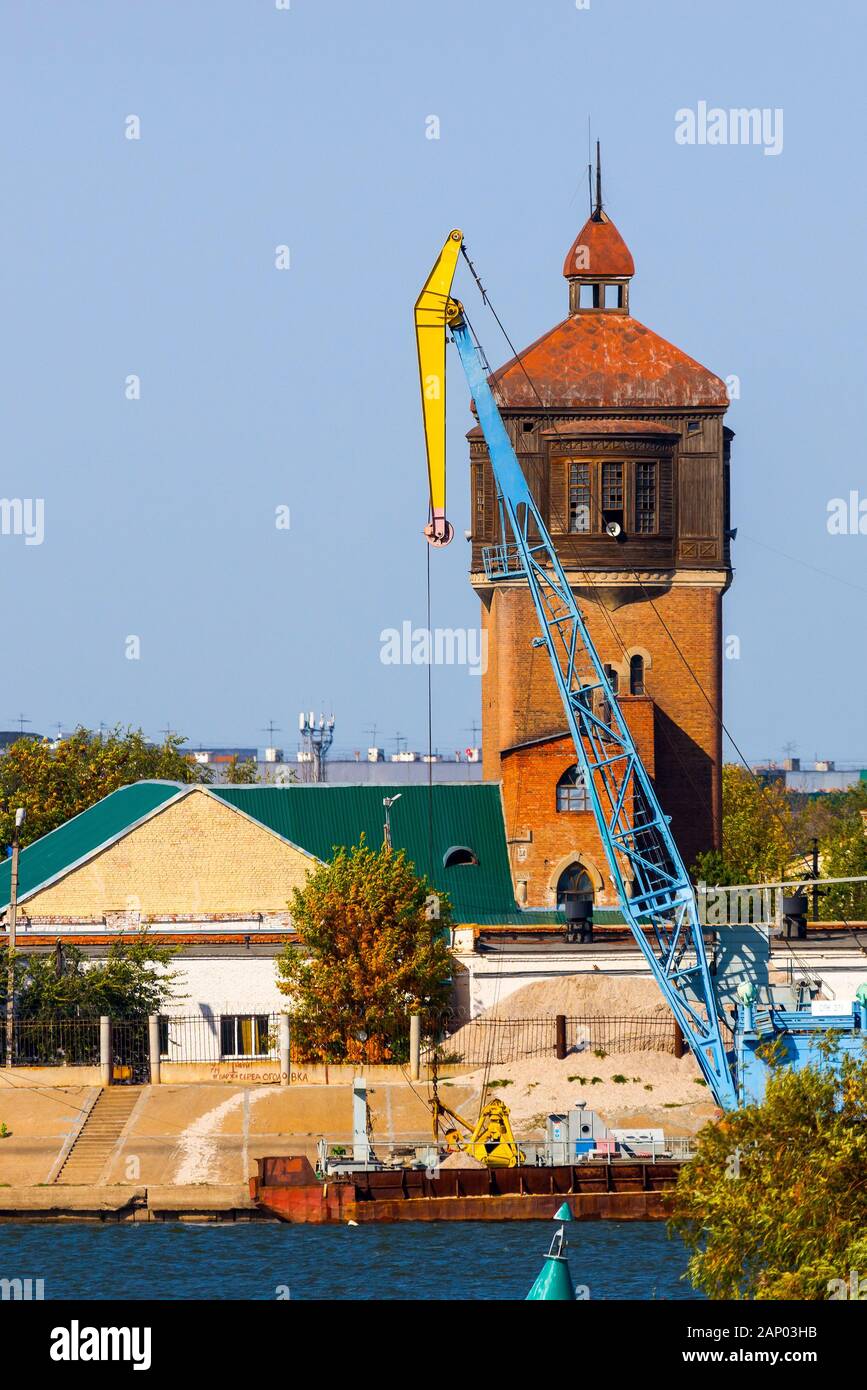 Old water-tower in river harbor. Port crane Stock Photo - Alamy