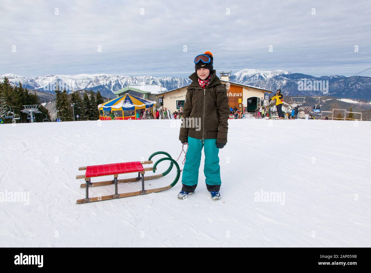 Ten year old boy with a toboggan at the top of Semmering ski resort ...