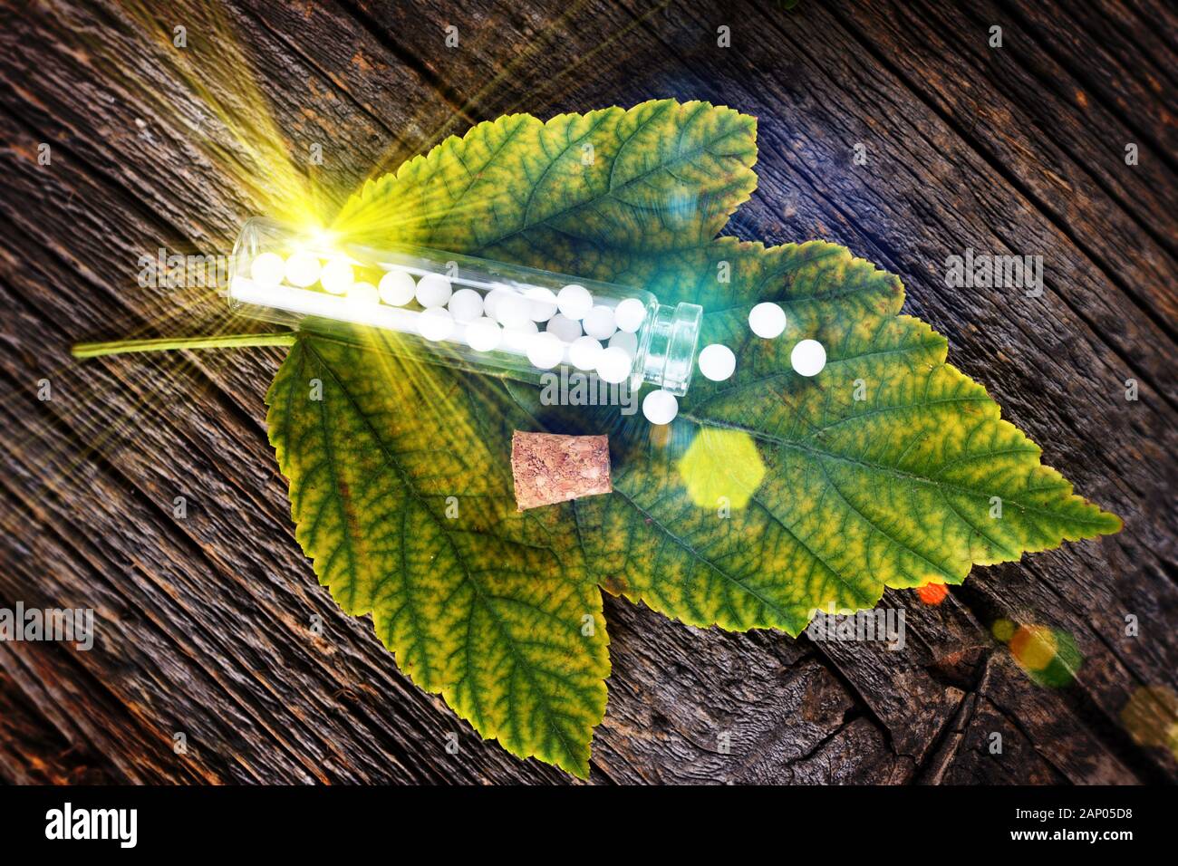 Homeopathic lactose sugar globules on leaf with glass bottle Stock ...