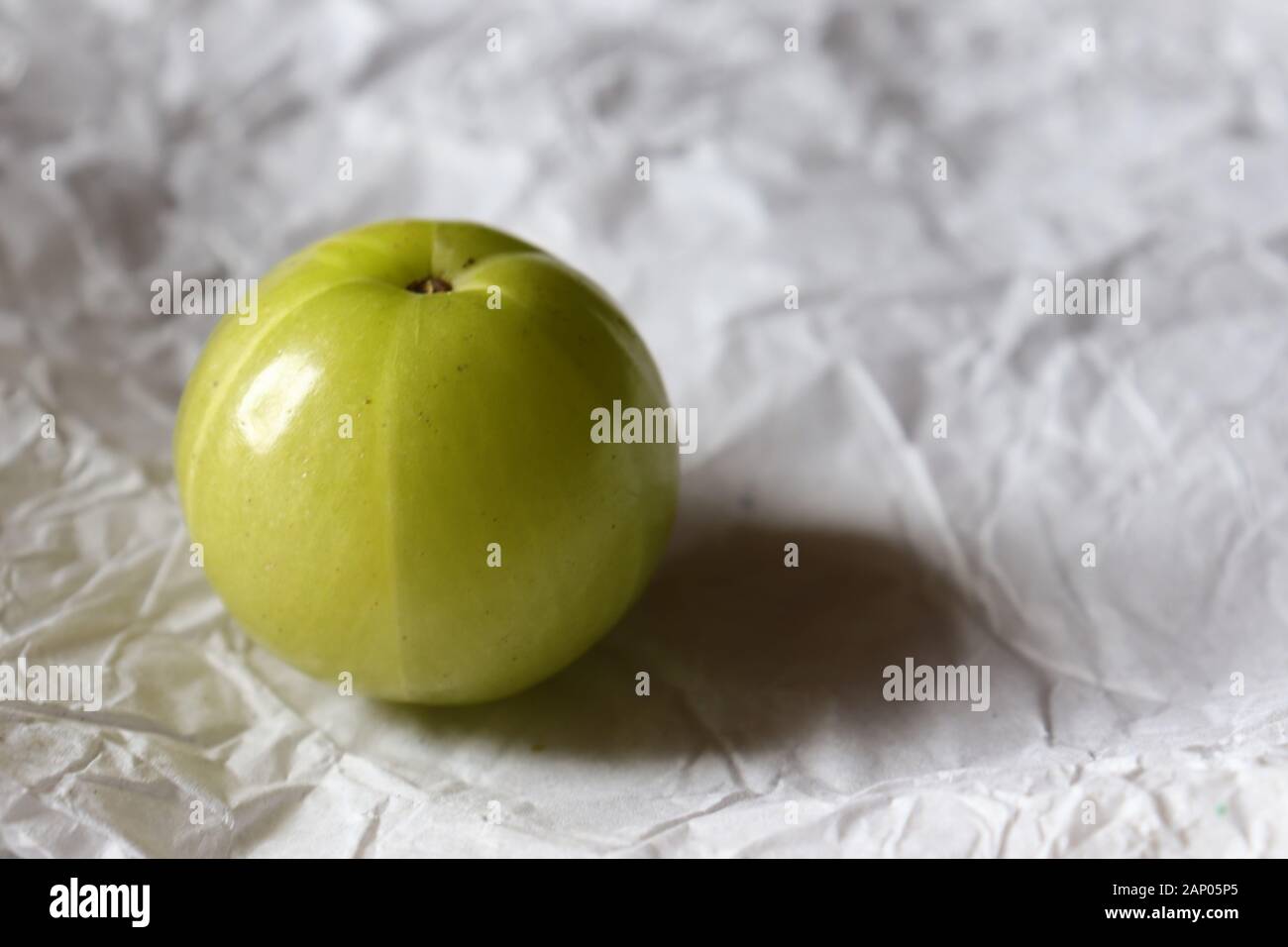 A single Indian gooseberry/amla against white background with copy ...
