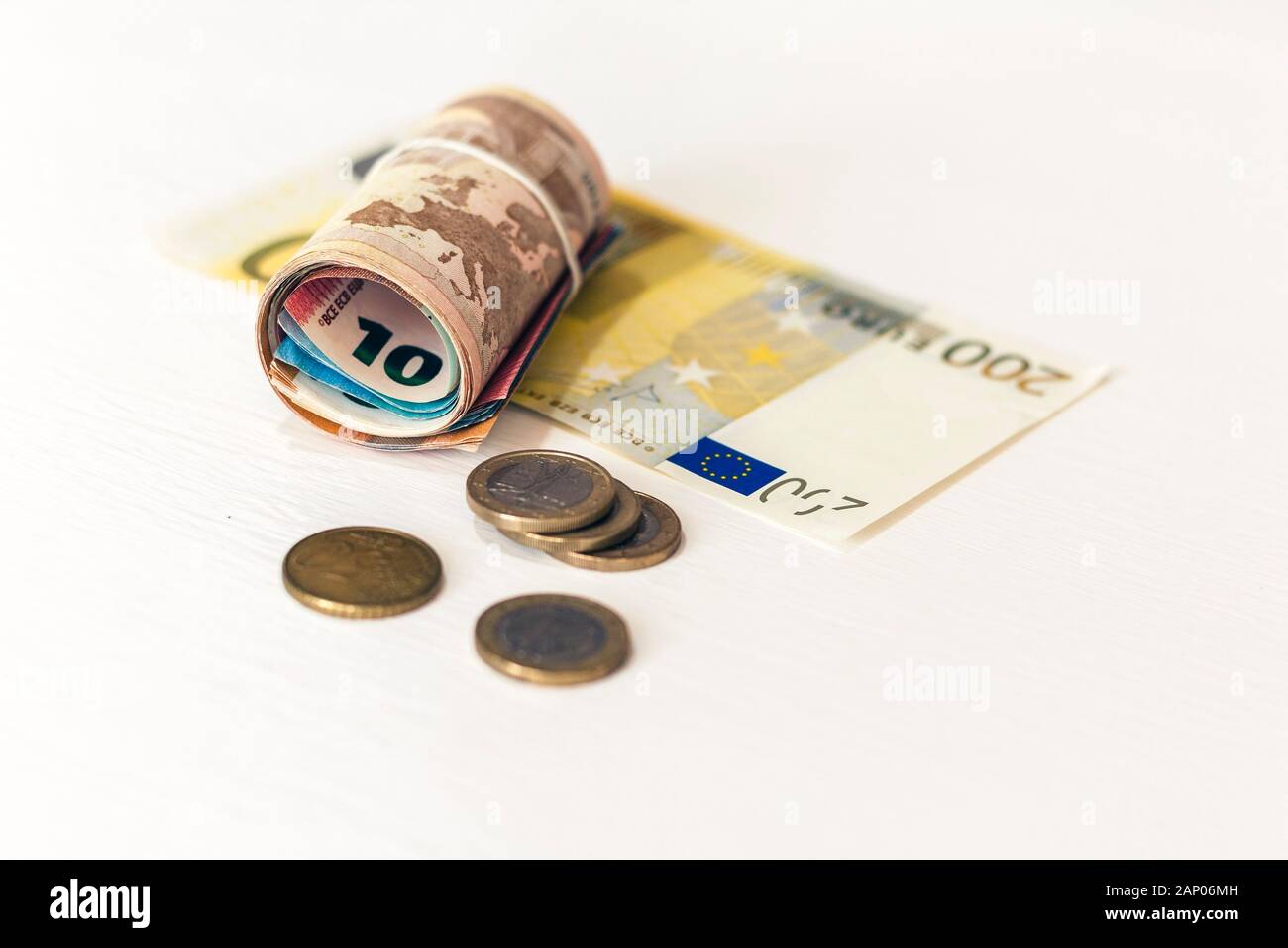 Rolled up money euro banknotes and coins on white background Stock ...