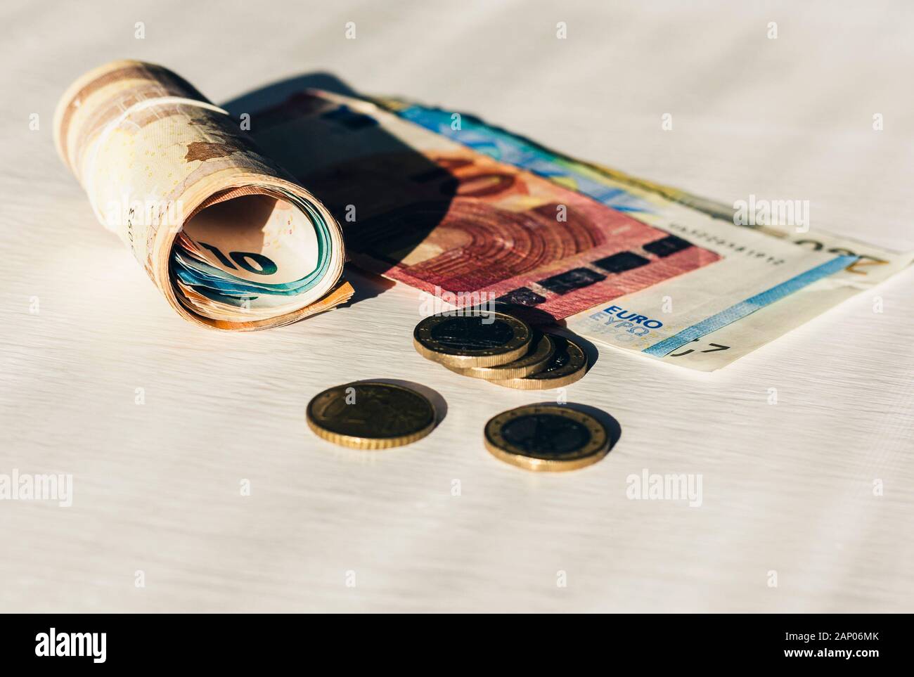 Rolled up money euro banknotes and coins on white background Stock ...