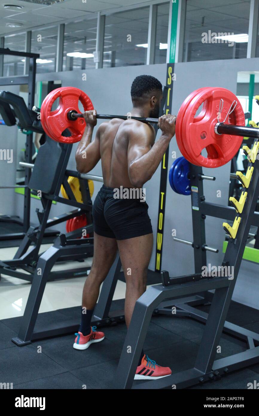 Fit young man in sportswear straining to lift heavy weights during a ...