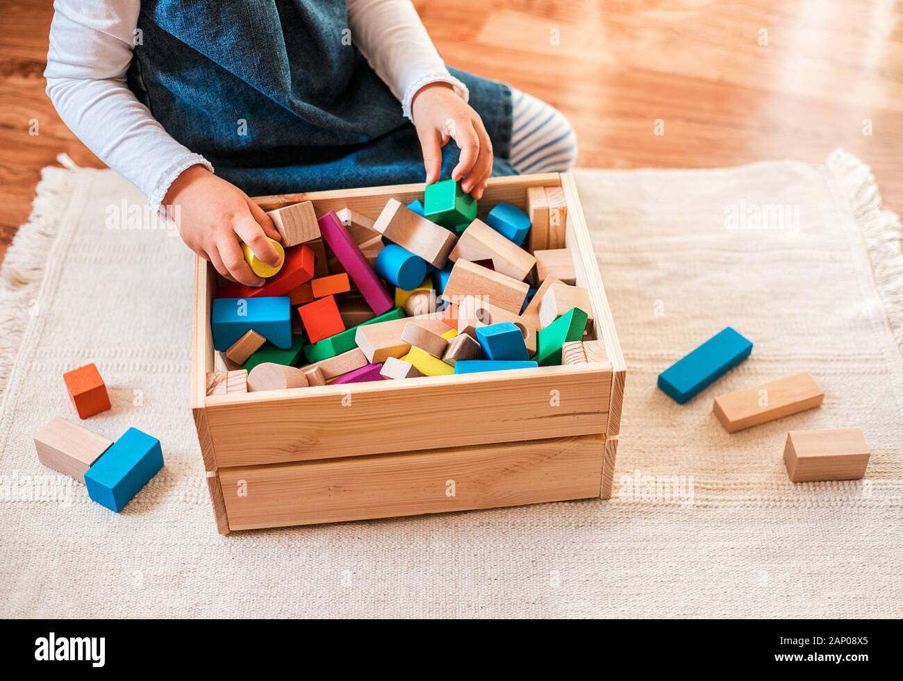 Little girl cleaning up the toy box at home. Child's space organization ...
