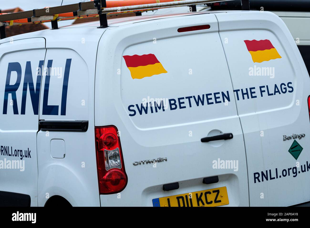 An RNLI van at the seaside with a signwritten notice advising swim ...