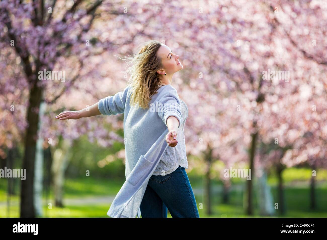 Young woman enjoying the nature in spring. Dancing, running and ...
